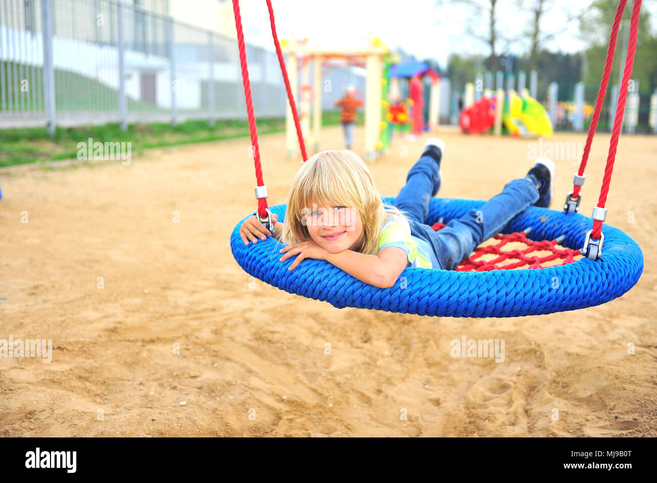 Pretty boy lying on swing, summer scene outdoors Stock Photo - Alamy