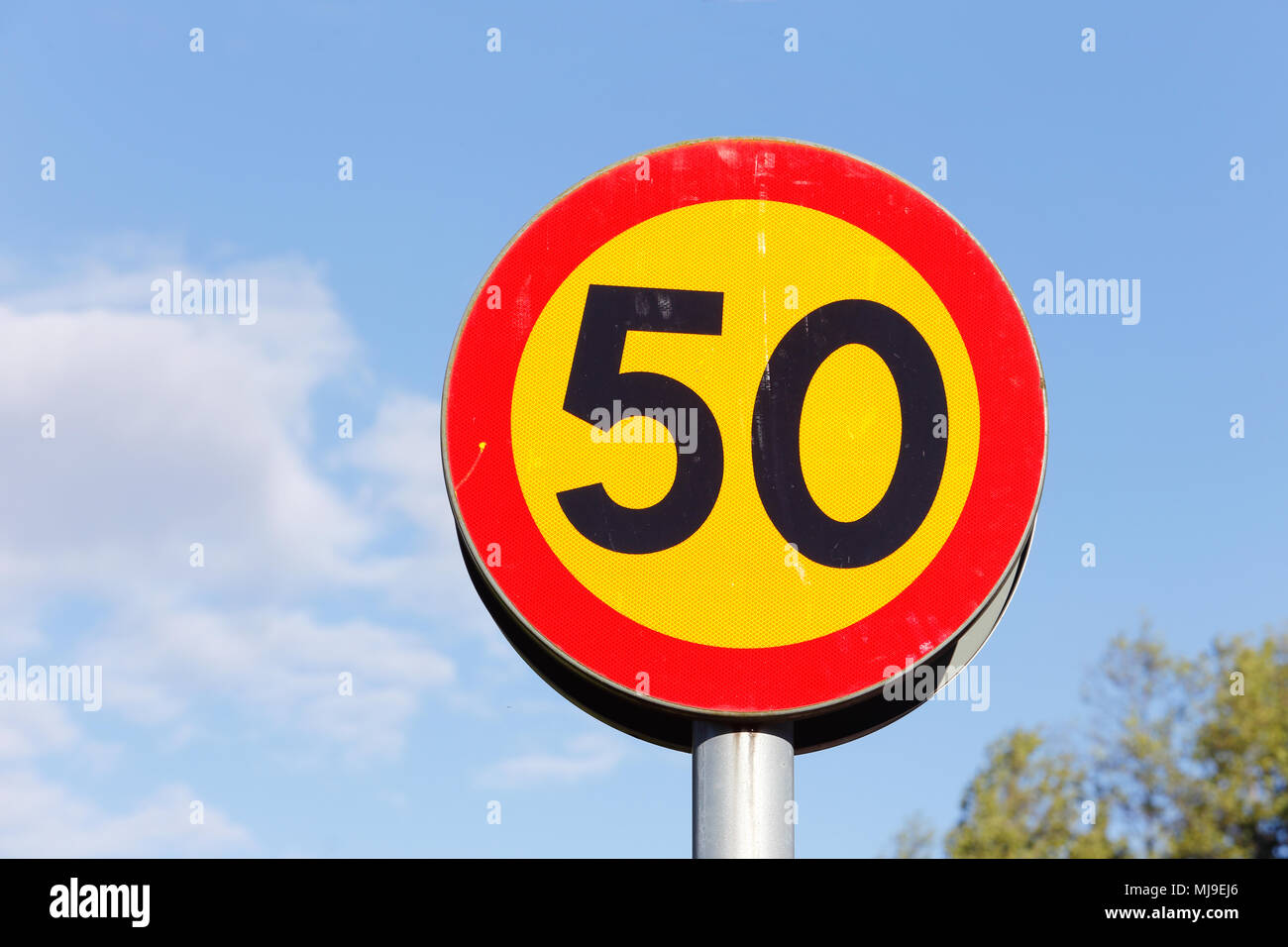 Road sign on pole speed limit 50 with black digits ob yellow background ...