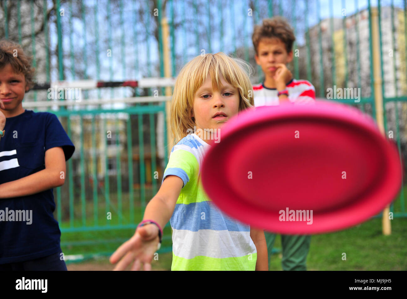 Kids with a flying disk outdoors Stock Photo - Alamy