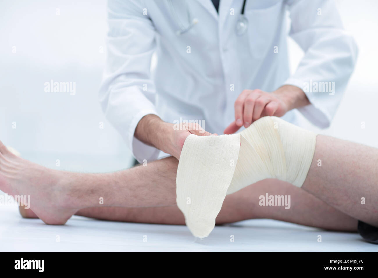doctor bandaging patient knee Stock Photo - Alamy