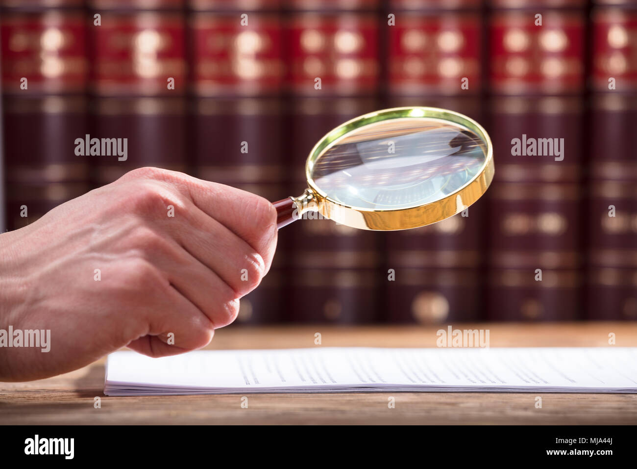 Human Hand Examining Document Through Magnifying Glass Stock Photo - Alamy