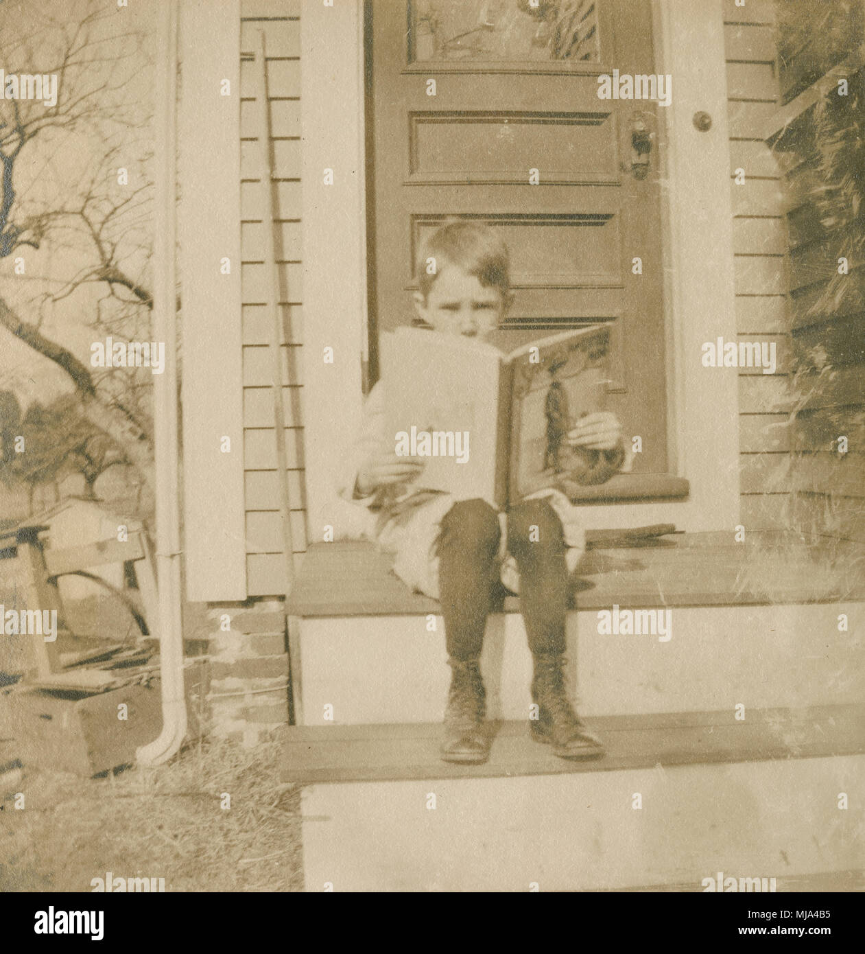 Antique c1905 photograph, young boy reading Victorian book on stairs ...