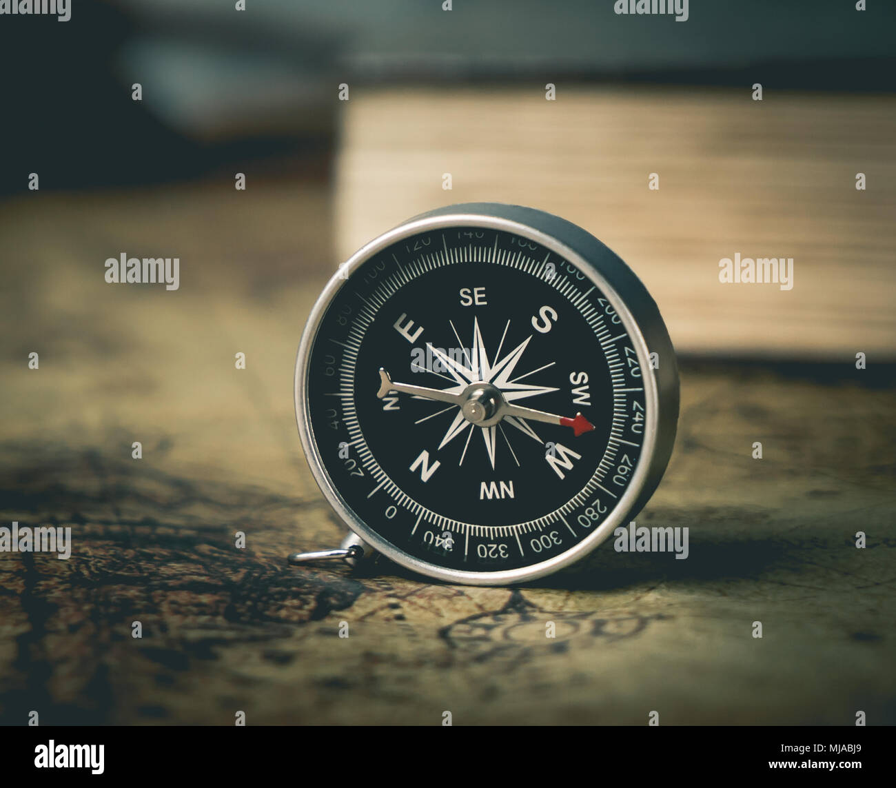 Vintage travel retro compass and vintage book Stock Photo - Alamy