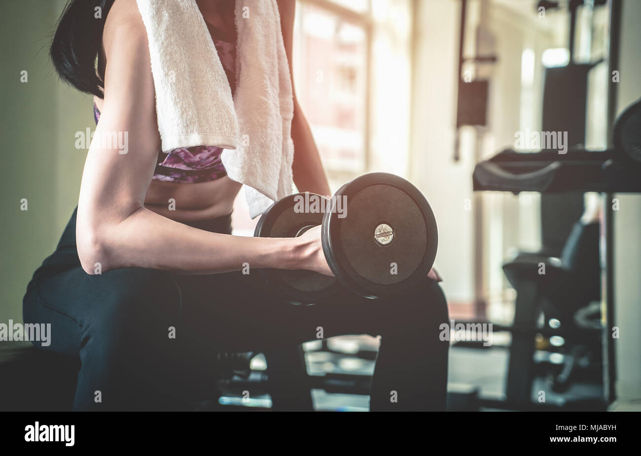 Strong Asian skinny woman is lifting dumbbell in fitness Stock Photo ...