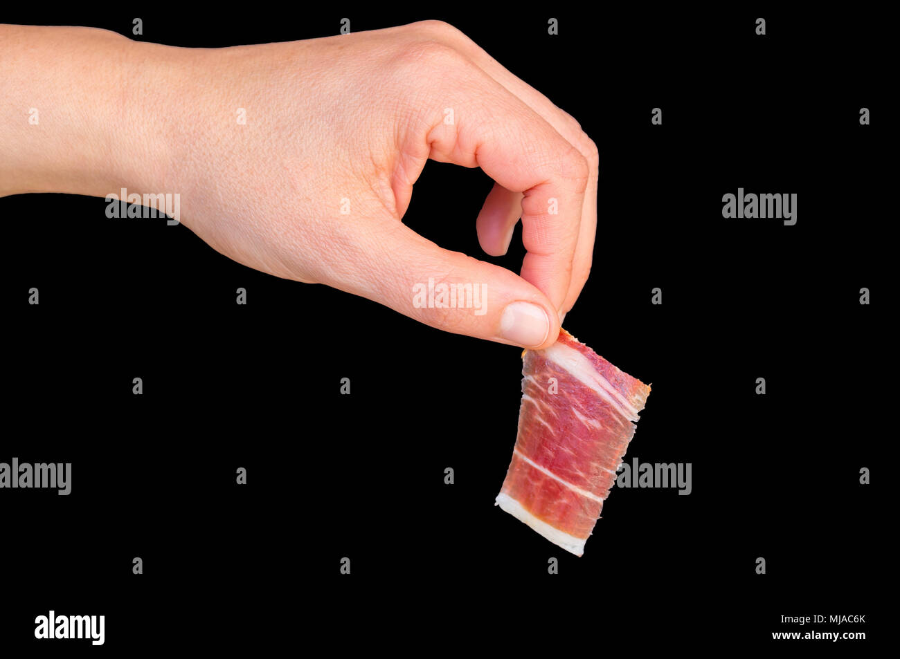 Side view of woman left hand picking serrano ham slice isolated over ...