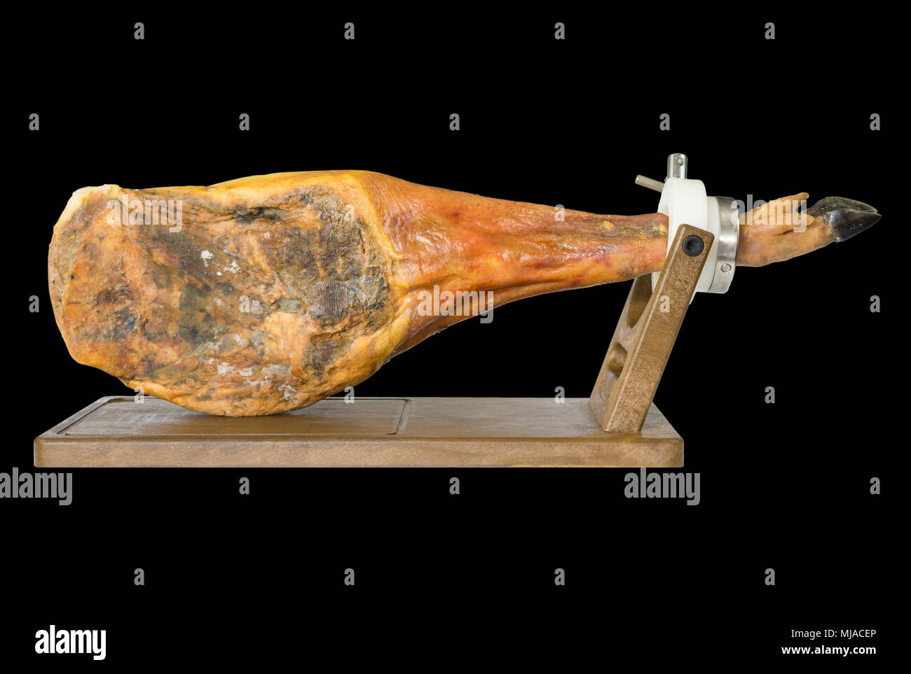 Side view of whole serrano ham leg over wood and black background Stock ...