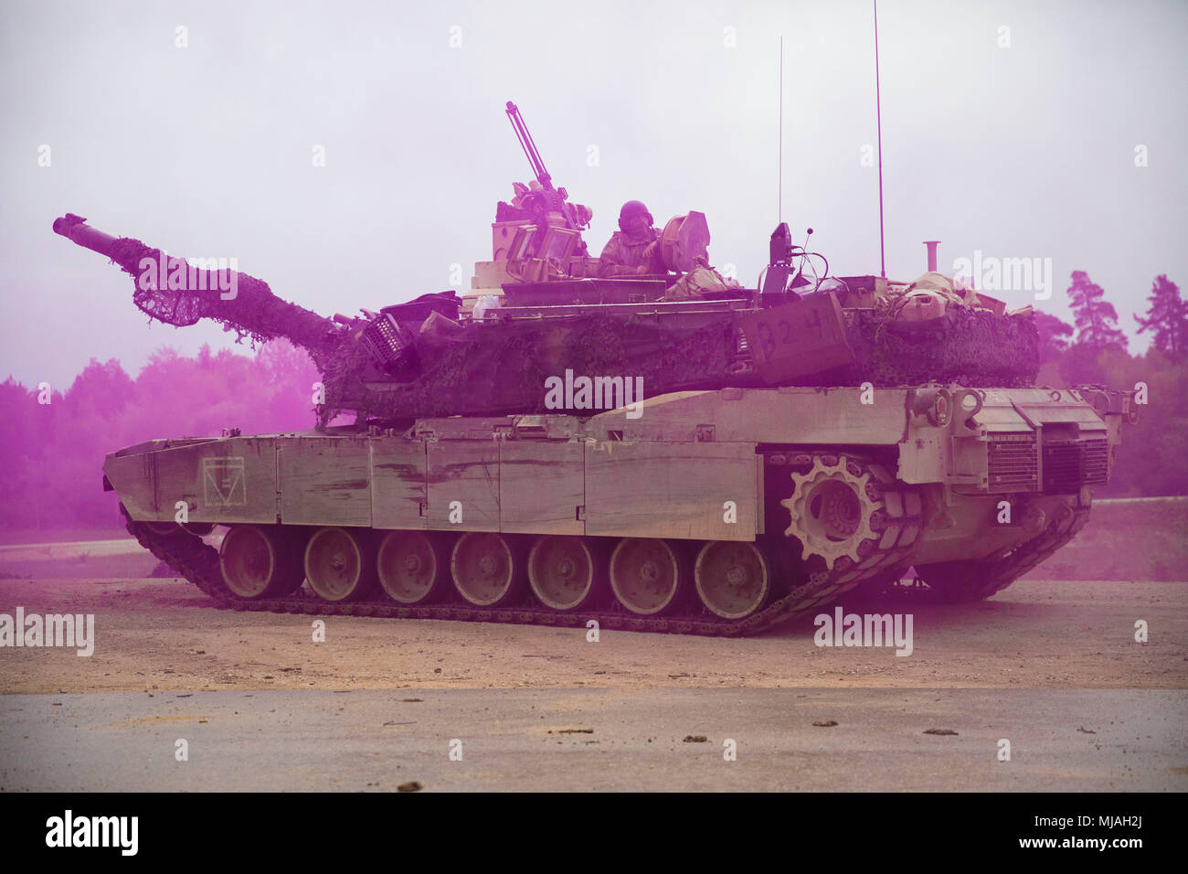 A purple smoke bomb, thrown for concealment of troop movement, coats a ...