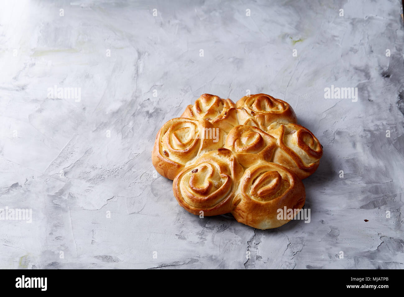 Homemade rose bread with raisins over white textured background, close ...