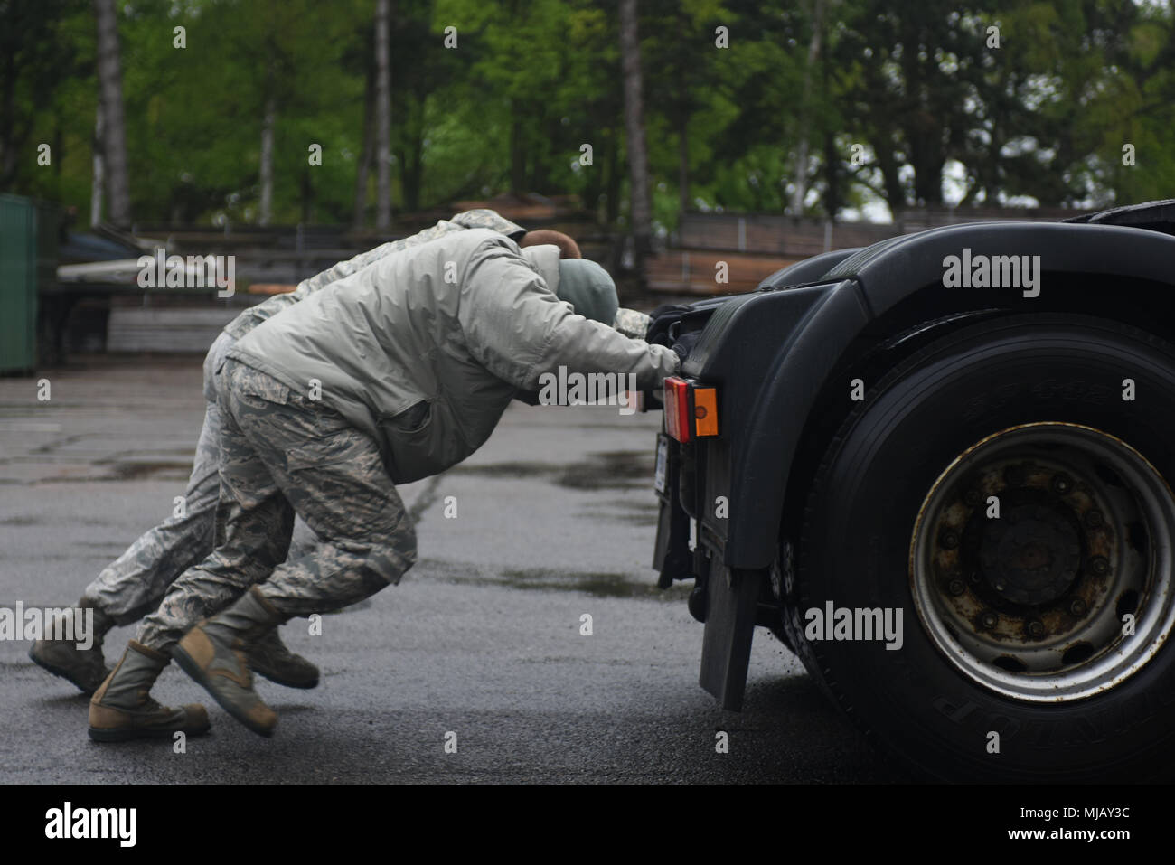 Airmen from the 48th Logistics Readiness Squadron push a tractor ...