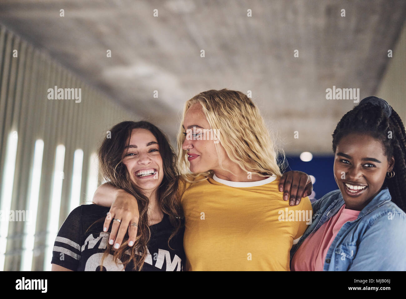 Diverse group of young girlfriends laughing and having fun while ...