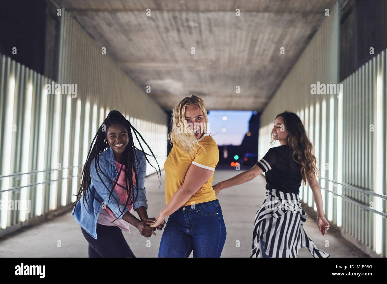 Laughing group of diverse young girlfriends having fun while walking ...