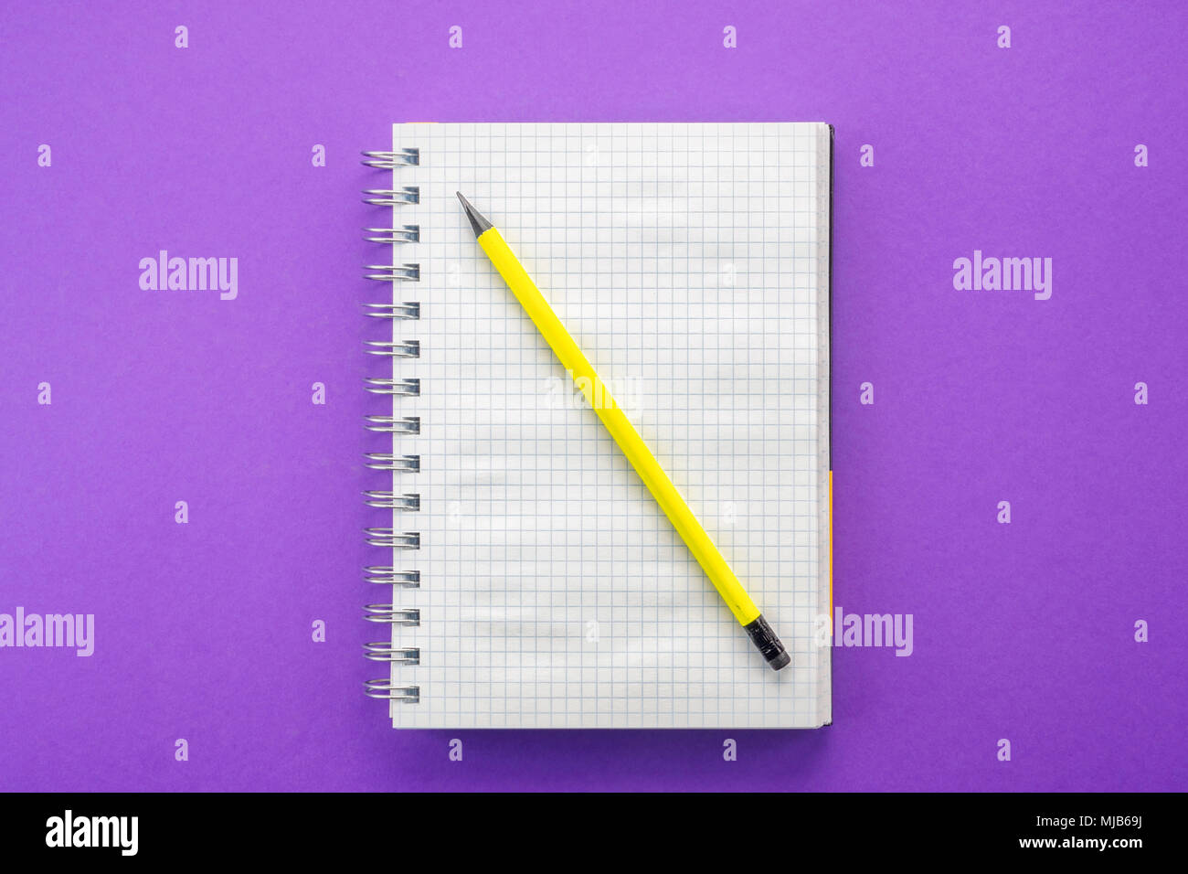 Notepad for notes and graphite pencil on purple paper background ...