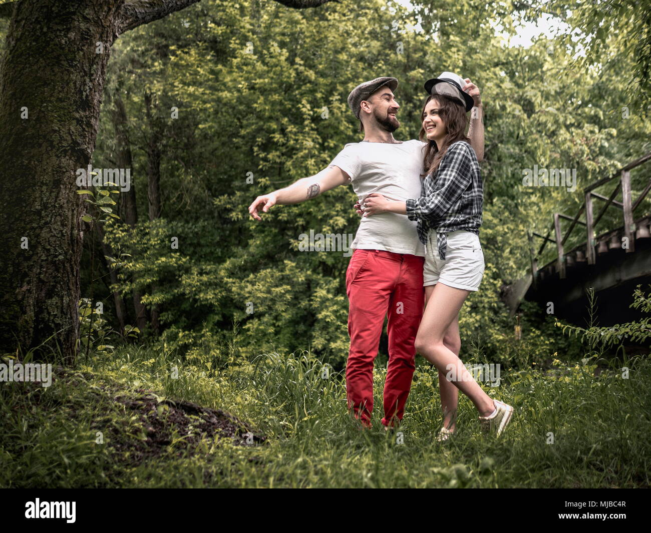 beautiful young couple man and woman jumping, hugging in the park Stock ...