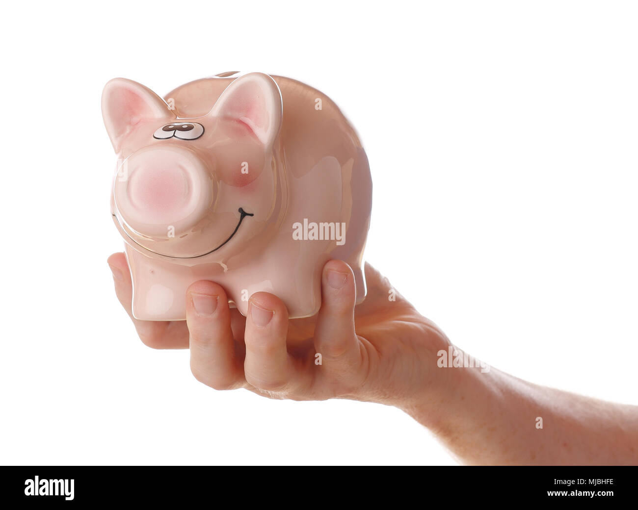 One human hand holding a pink happy piggy bank on white background ...