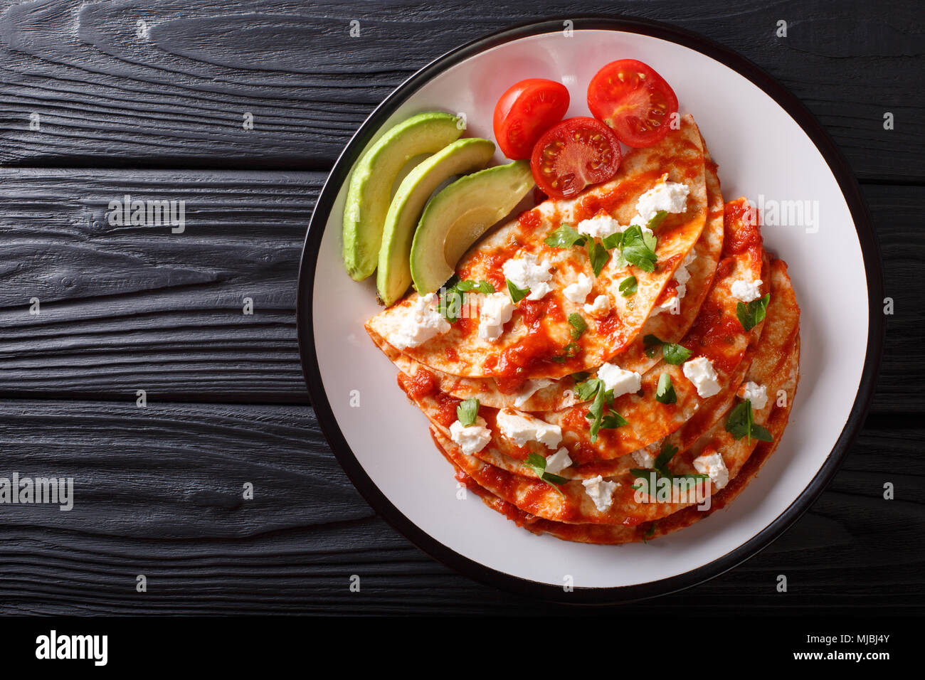 Serving Mexican Entomatadas with cottage cheese, tomato sauce, greens ...