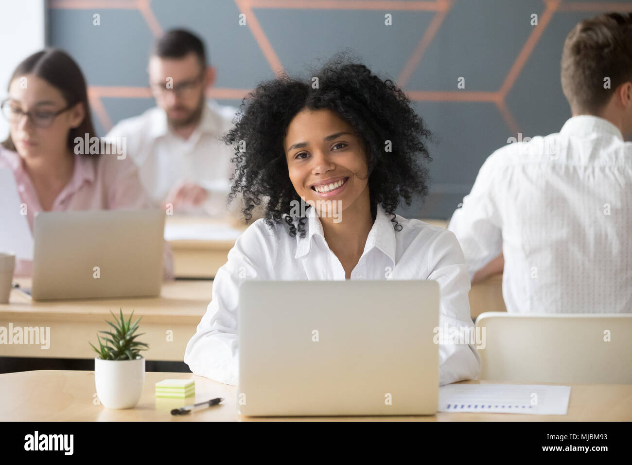 Smiling african woman employee student looking at camera in cowo Stock ...