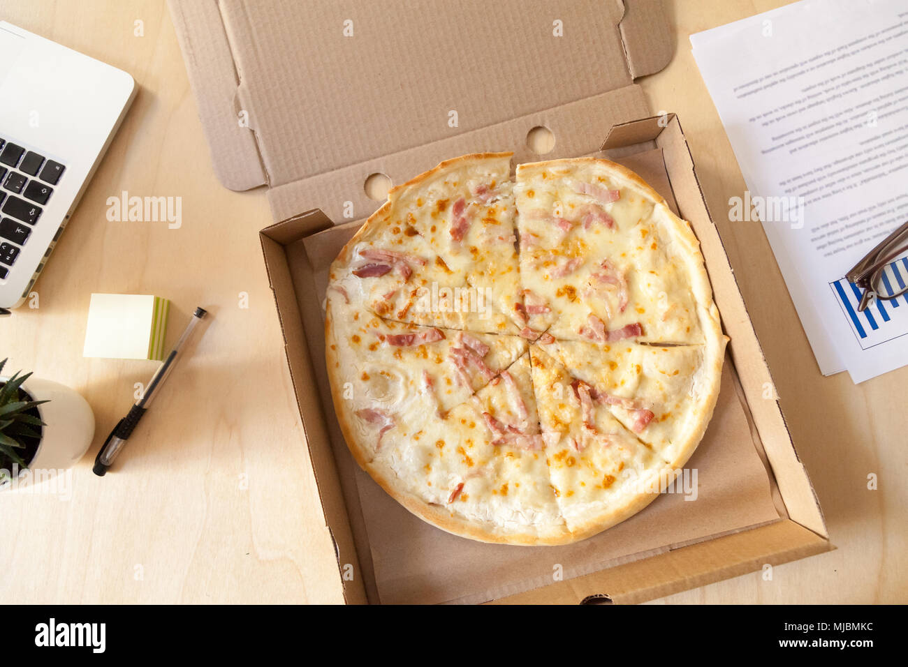 Italian pizza in cardboard box on work desk, top view Stock Photo - Alamy