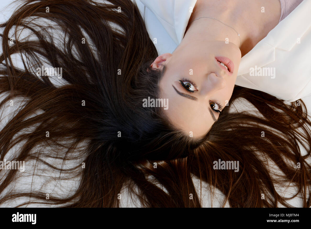 Beautiful long hair woman lie on floor Stock Photo - Alamy