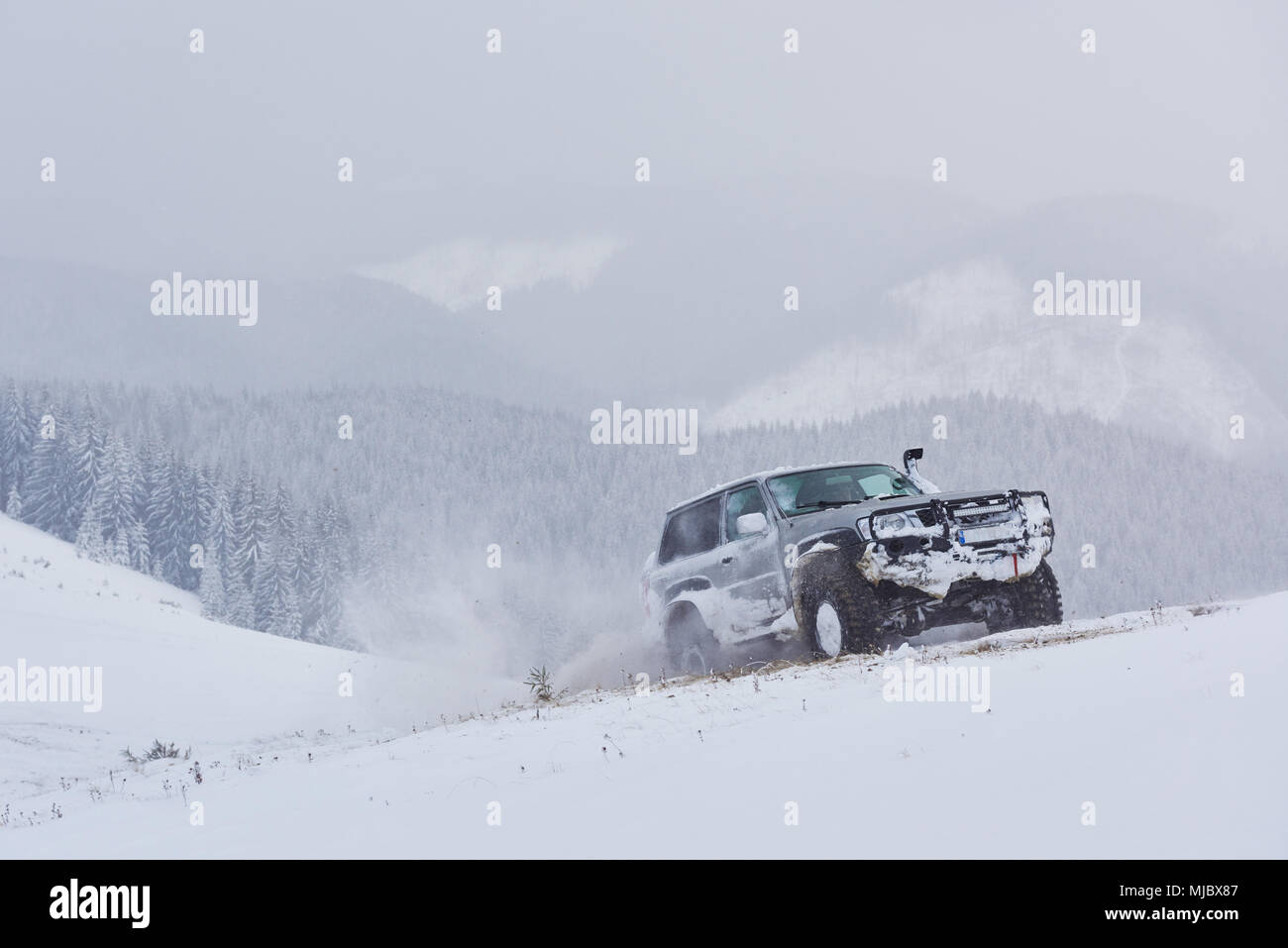 SUV rides on a winter mountians driving risk of snow and ice, drifting ...