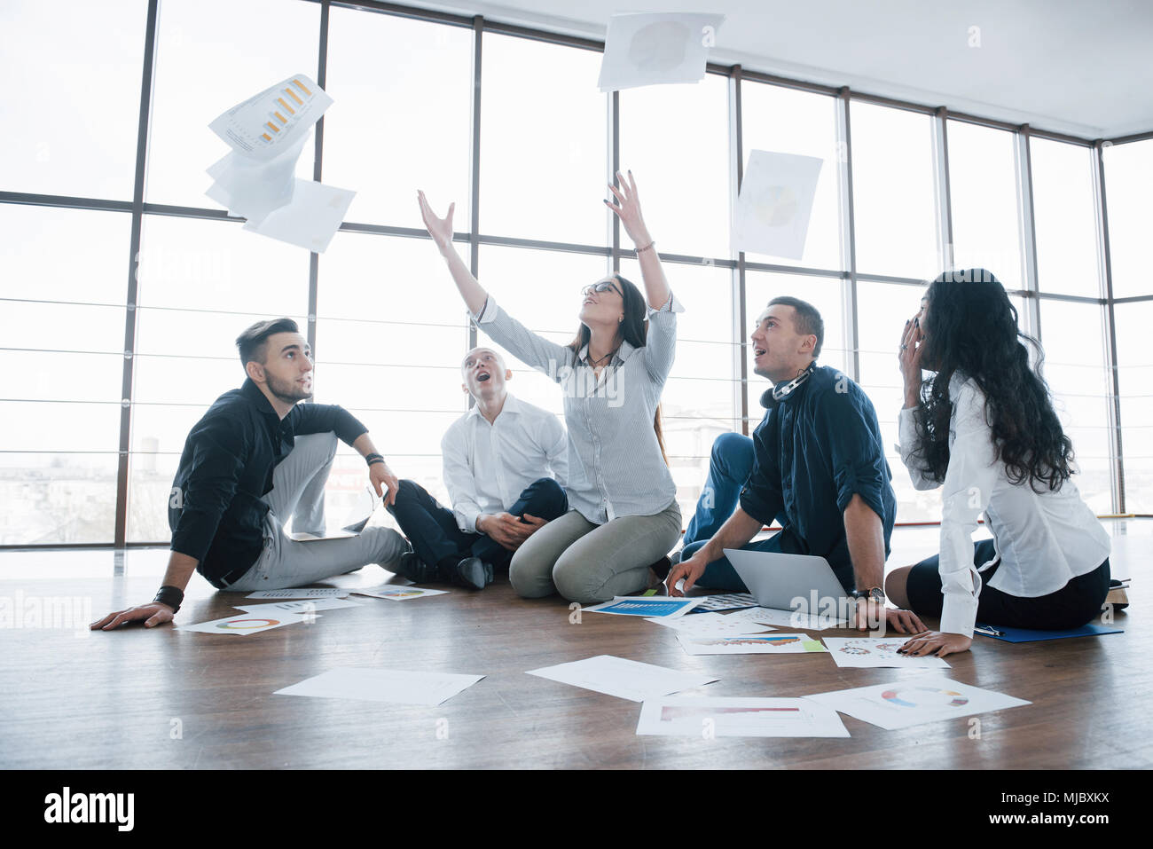 Success strategy together. Cheerful business colleagues tossing papers ...