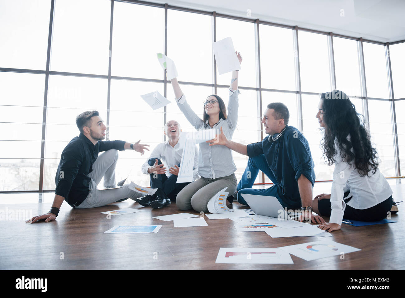 Success strategy together. Cheerful business colleagues tossing papers ...