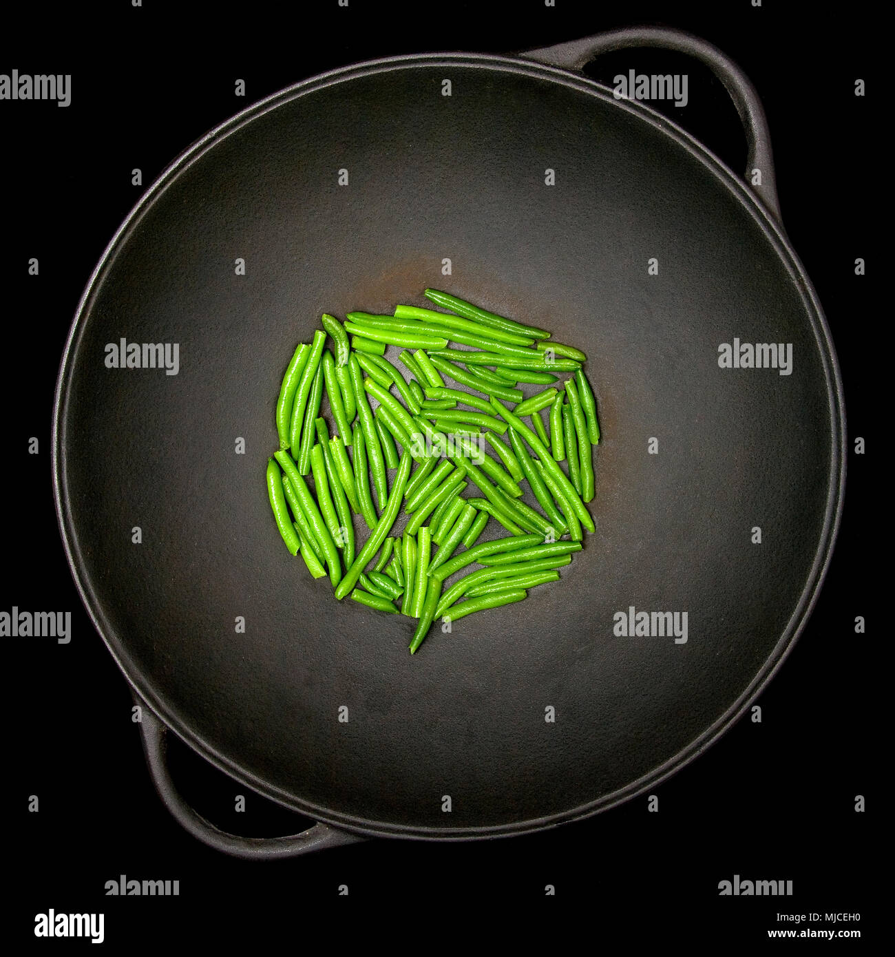 pole beans in a wok pan, green and black Stock Photo - Alamy