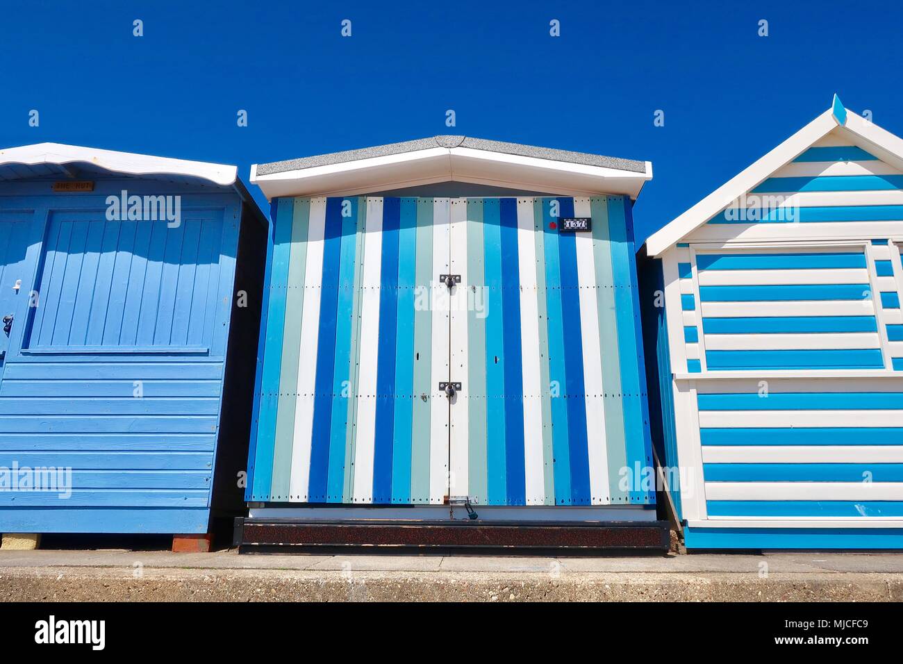 Blue green and white stripe multi coloured beach huts at Walton on the ...