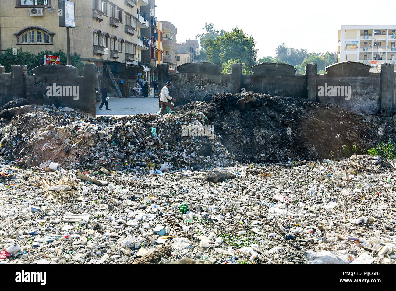 An Egyptian man sorting through a pile of rubbish in the street in the ...