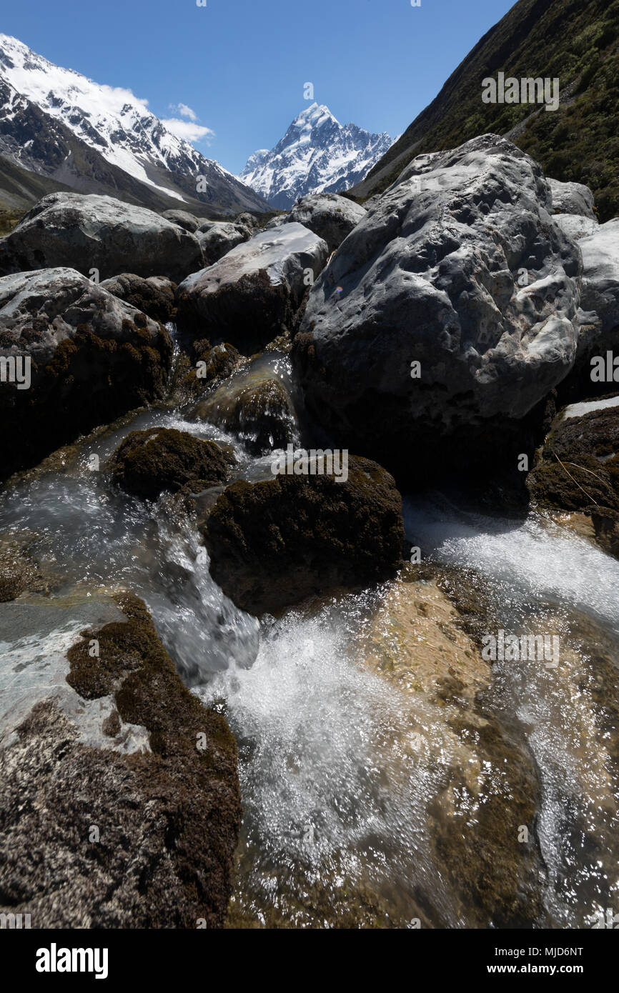 Mount Cook shown with river flowing over rocks in the foreground, Mount ...