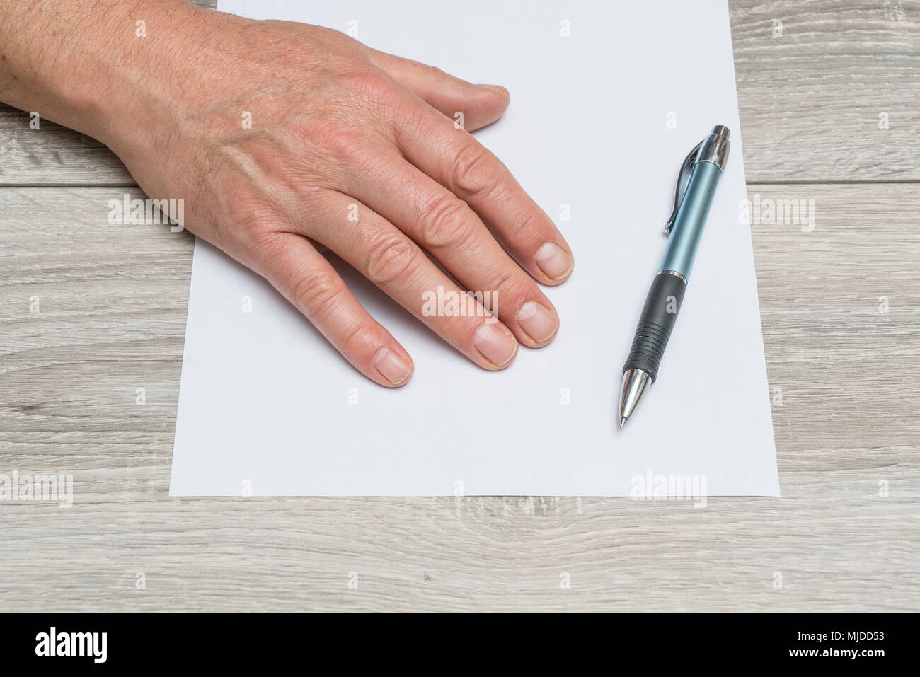 the gesture of a man while he is about to write on a white sheet Stock ...