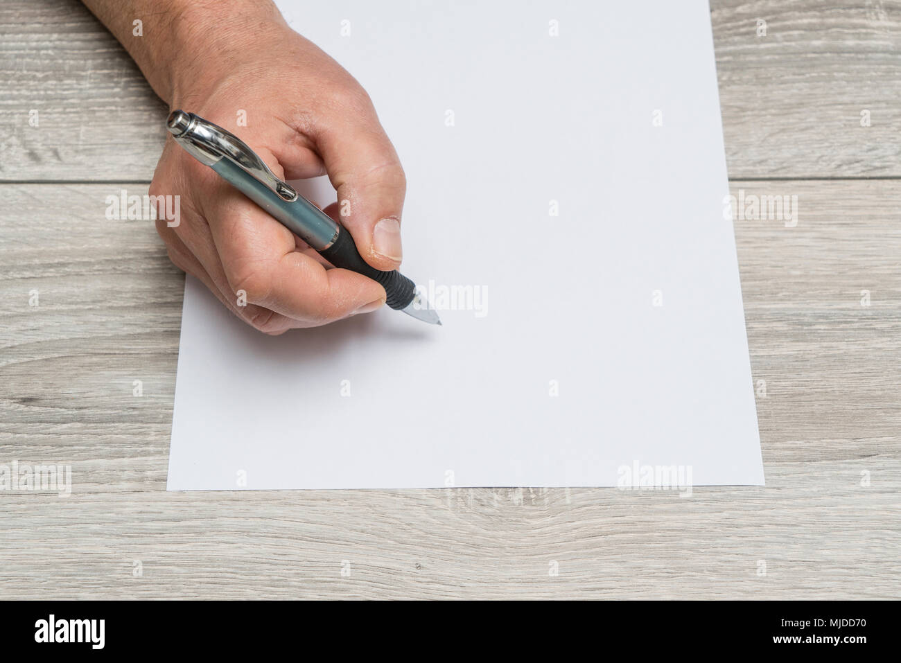 the gesture of a man while he is about to write on a white sheet Stock ...