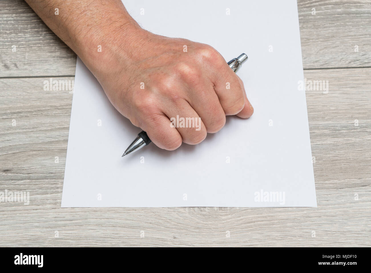 the gesture of a man while he is about to write on a white sheet Stock ...