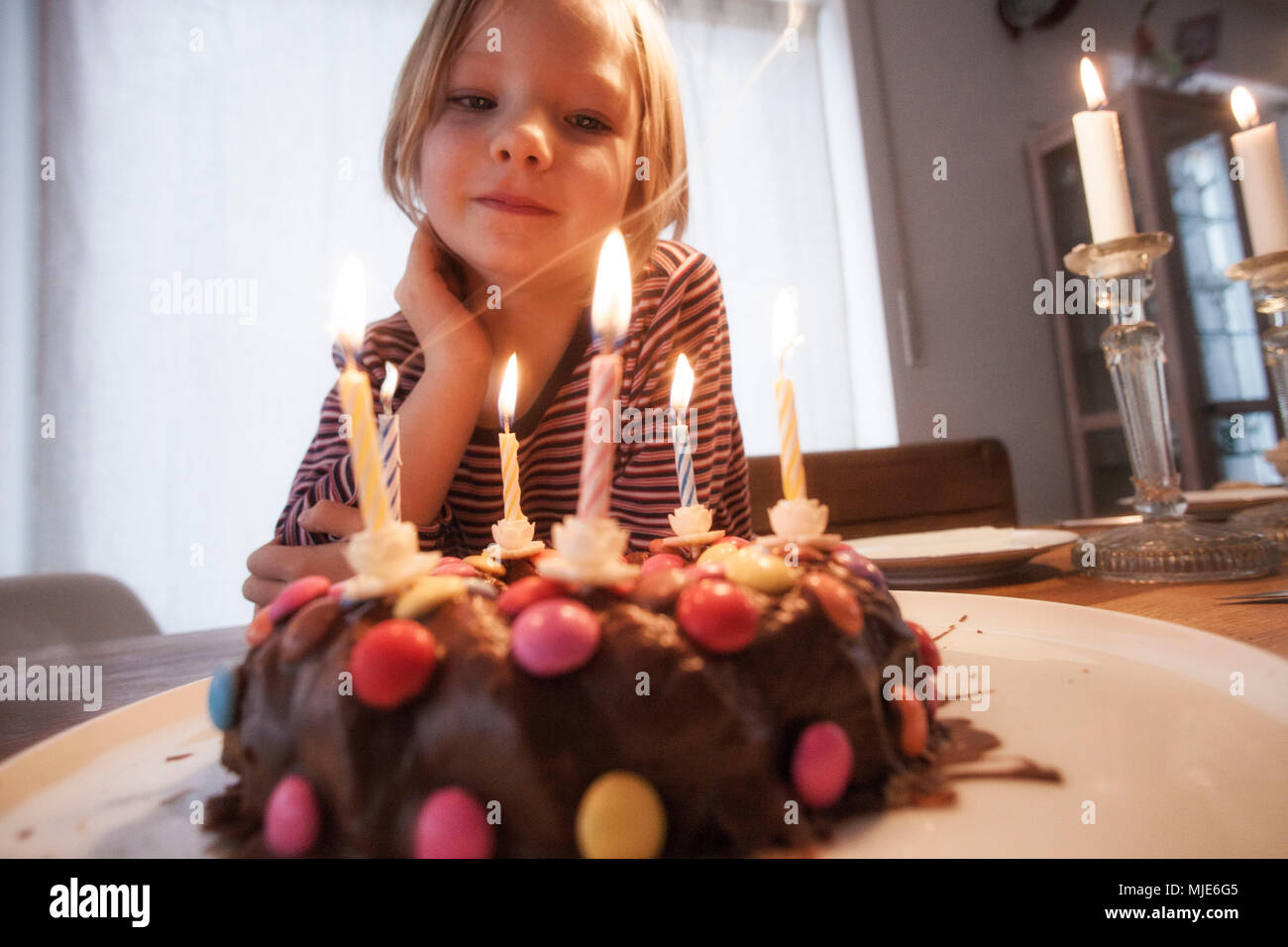 Small girl in front of birthday cake Stock Photo - Alamy
