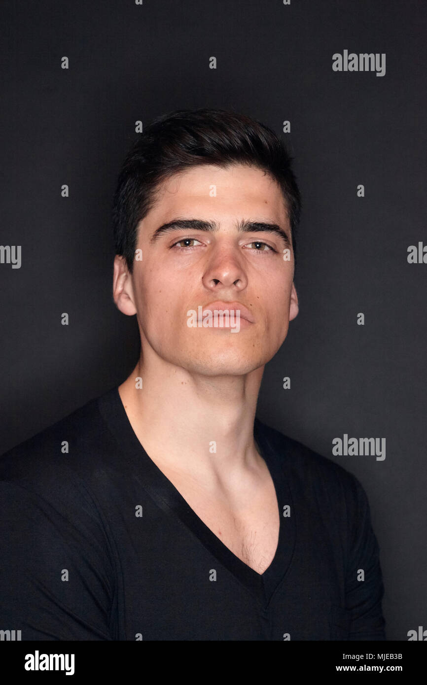 one young handsome man, model wearing t-shirt, simple studio upper body ...