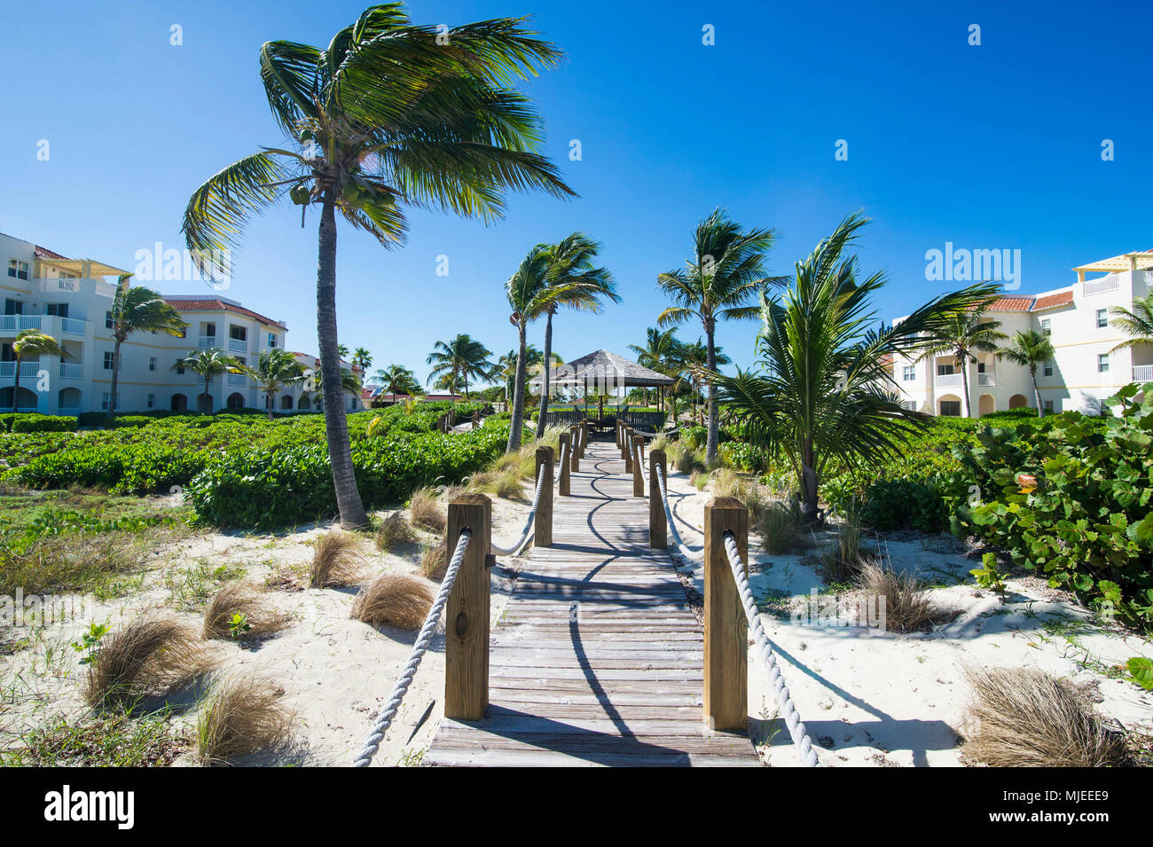 Wooden pathway leading to the turquoise waters of Providenciales, Turks ...
