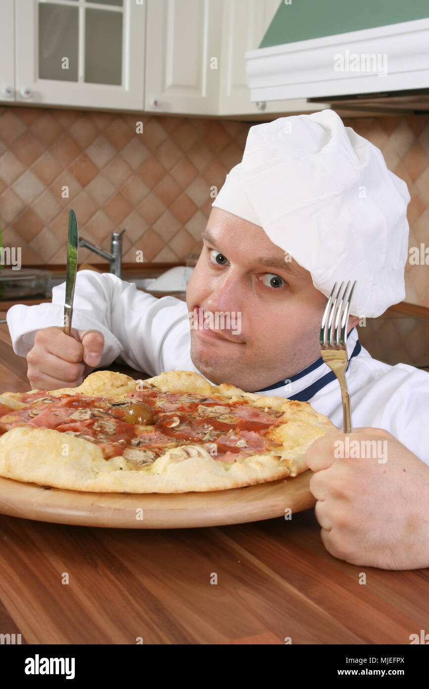 Crazy chef is prepared for eating pizza with fork and knife Stock Photo ...