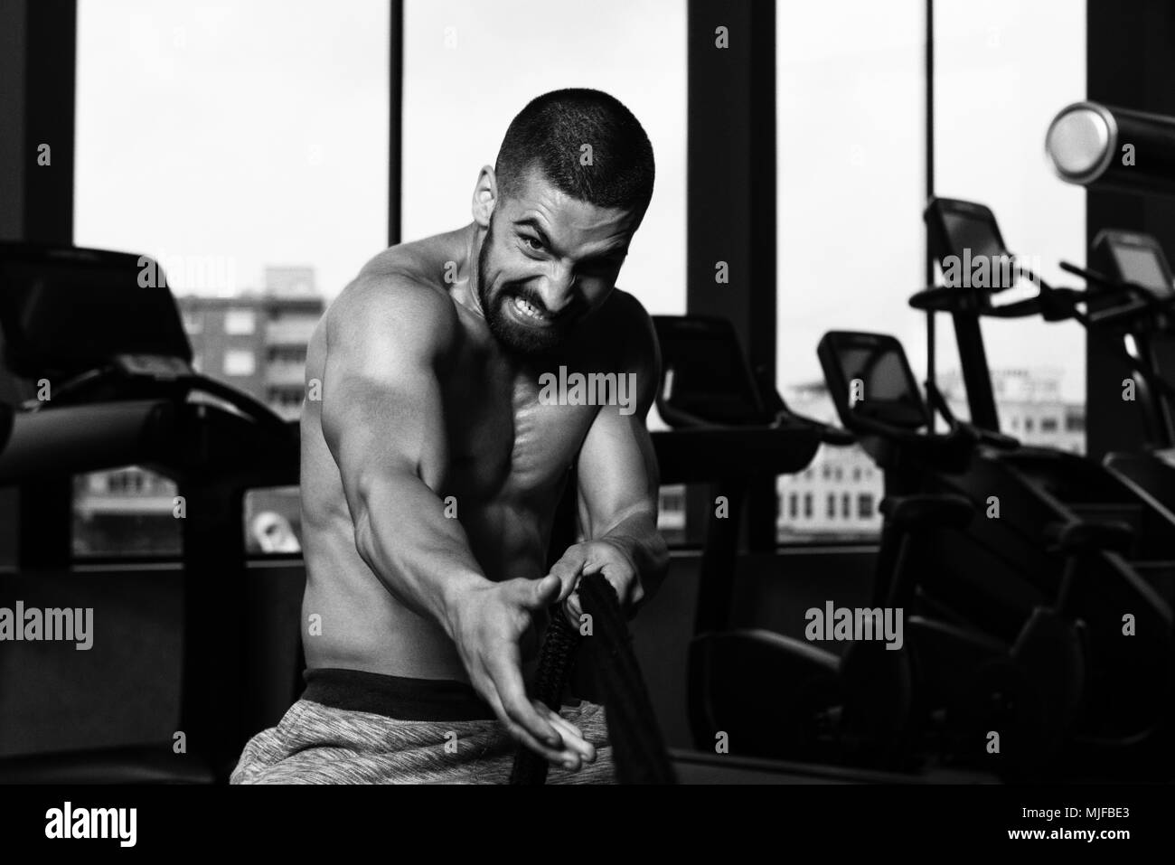 Battling Ropes Young Man At Gym Workout Exercise Stock Photo - Alamy