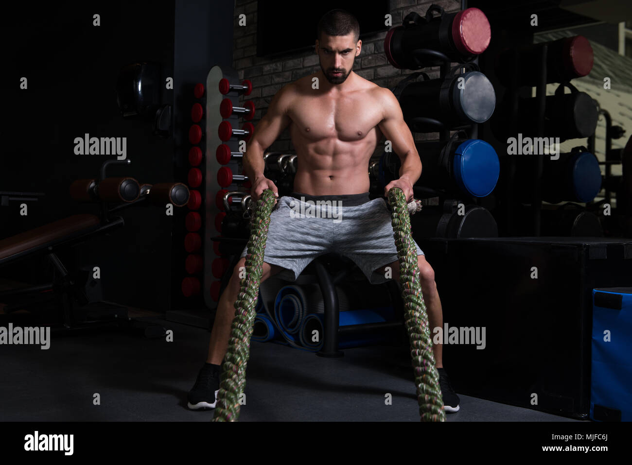 Battling Ropes Young Man At Gym Workout Exercise Stock Photo - Alamy