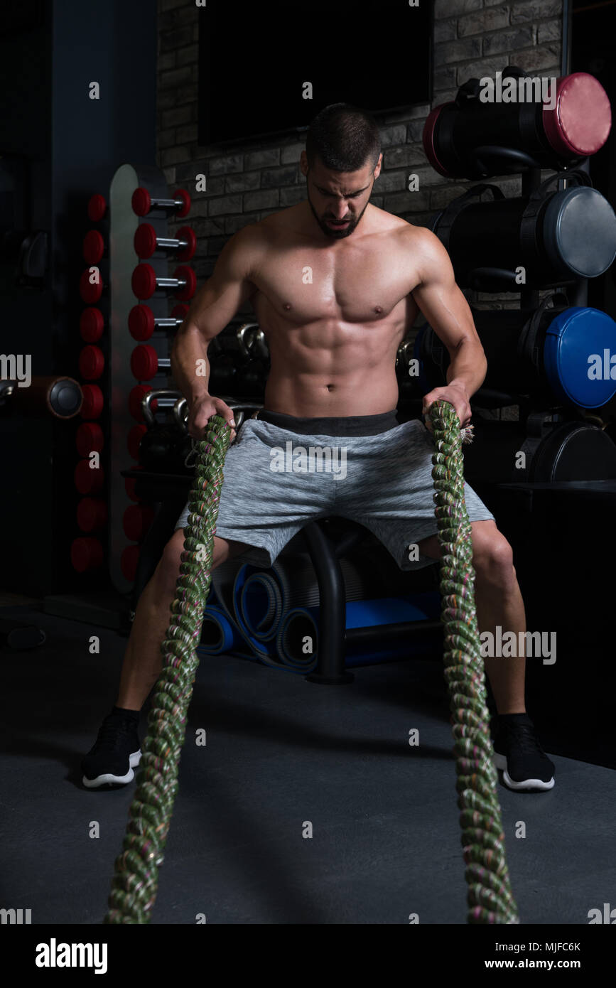 Battling Ropes Young Man At Gym Workout Exercise Stock Photo - Alamy