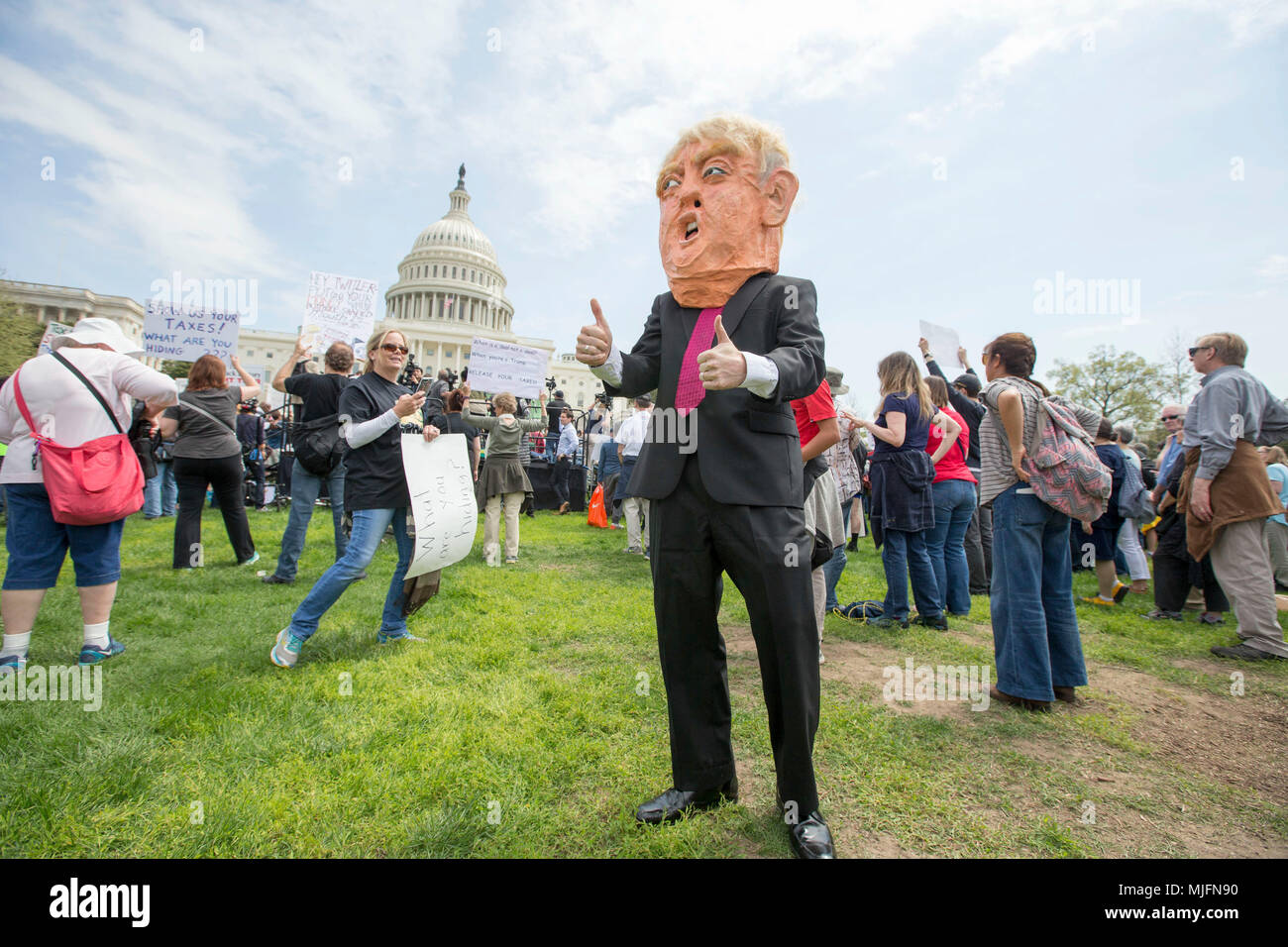 A protestor wearing a Donald Trump paper mache mask at the Tax March ...
