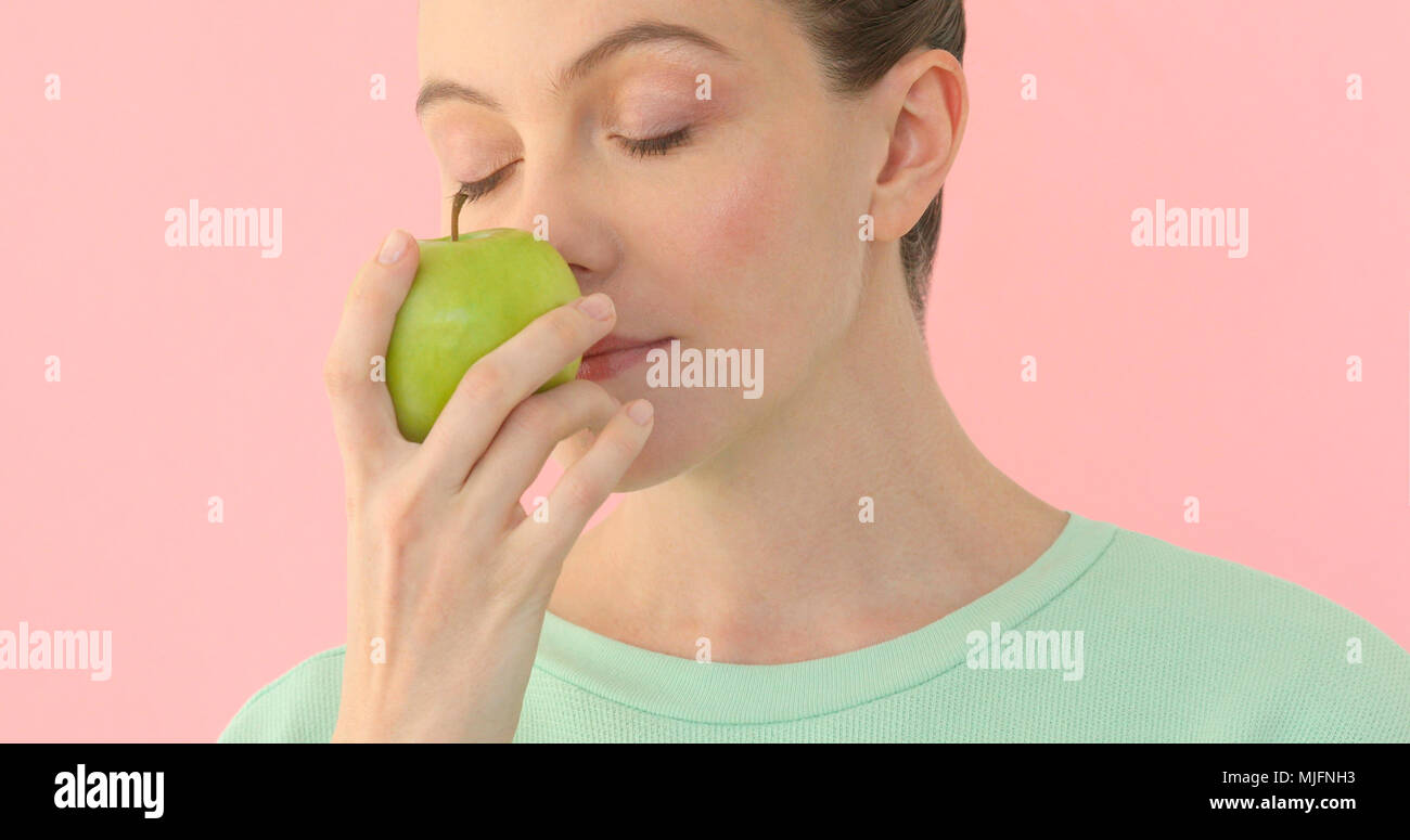 Beautiful girl enjoys smell apple Stock Photo - Alamy