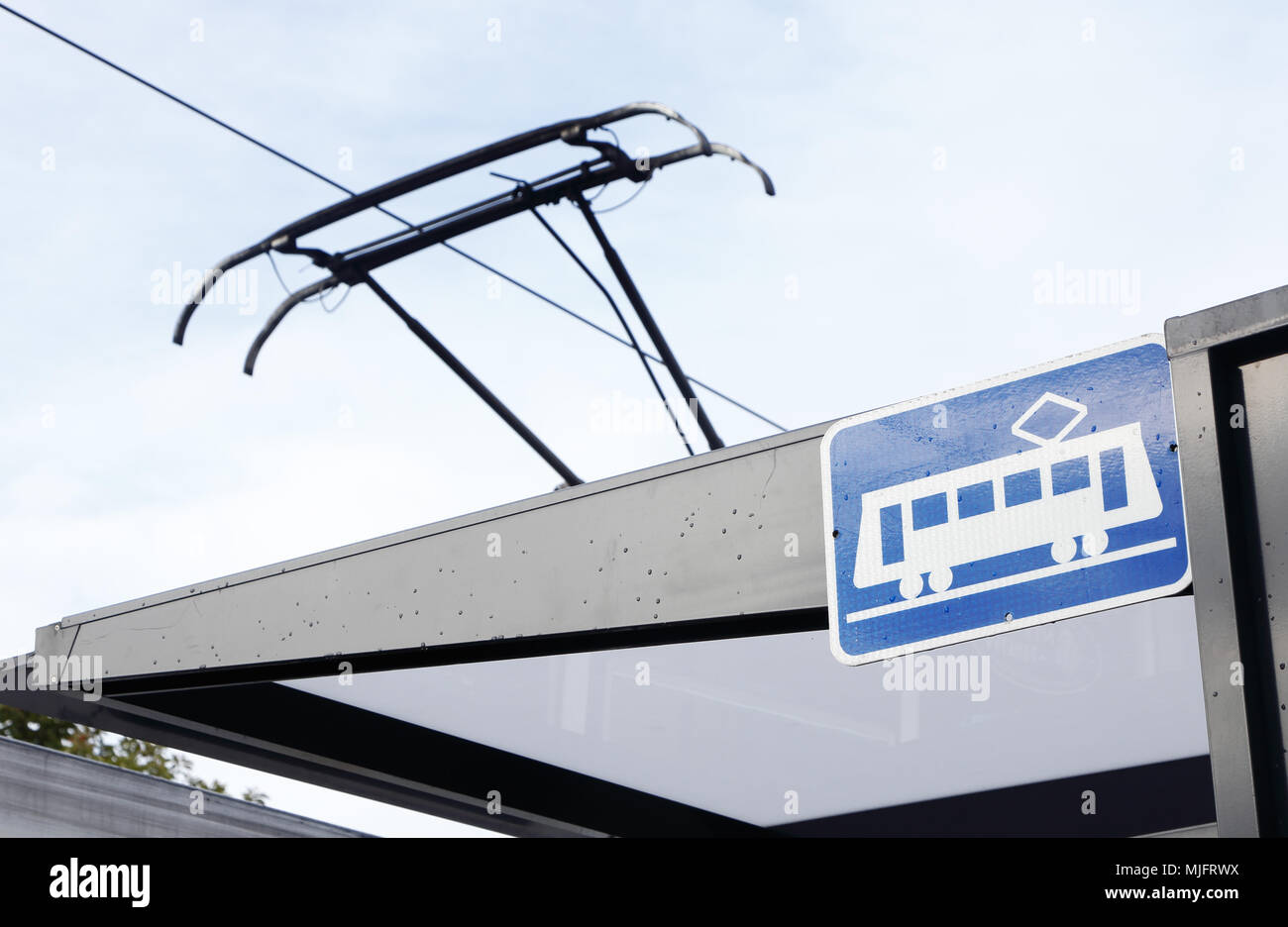 A tram stop with tram stop sign and the pantograph of an electric ...