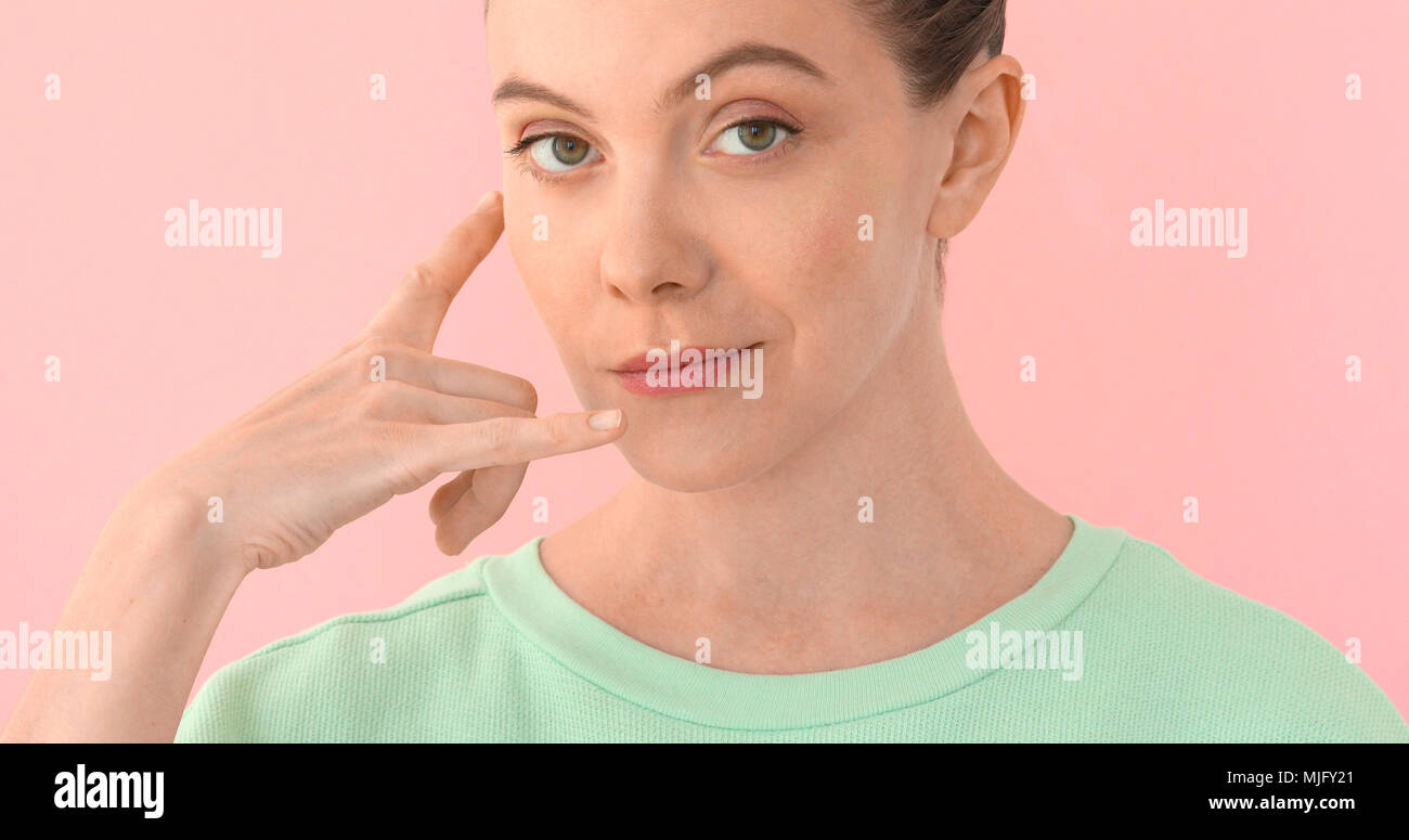 Beautiful woman gesturing call me pink background Stock Photo - Alamy