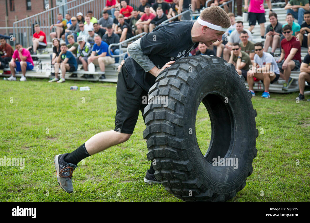 U.S. Marine Corps Capt. Vincent Curley flips a tire during Marine Light ...