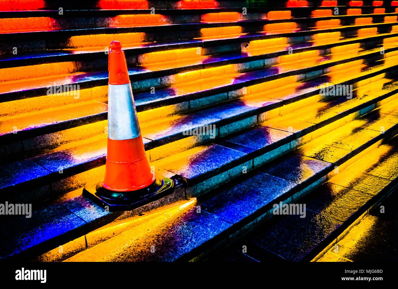 Isolated traffic cone on stair case with colorful yellow and orange ...