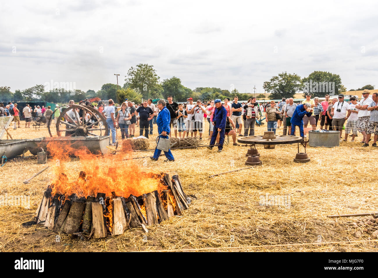 Old trade wheelwright giving demonstration on wooden wheel building and ...