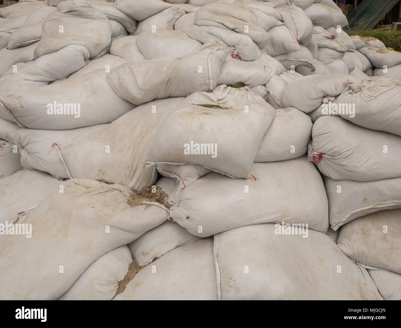 Background. White sandbag bags are full with sand, water flood ...