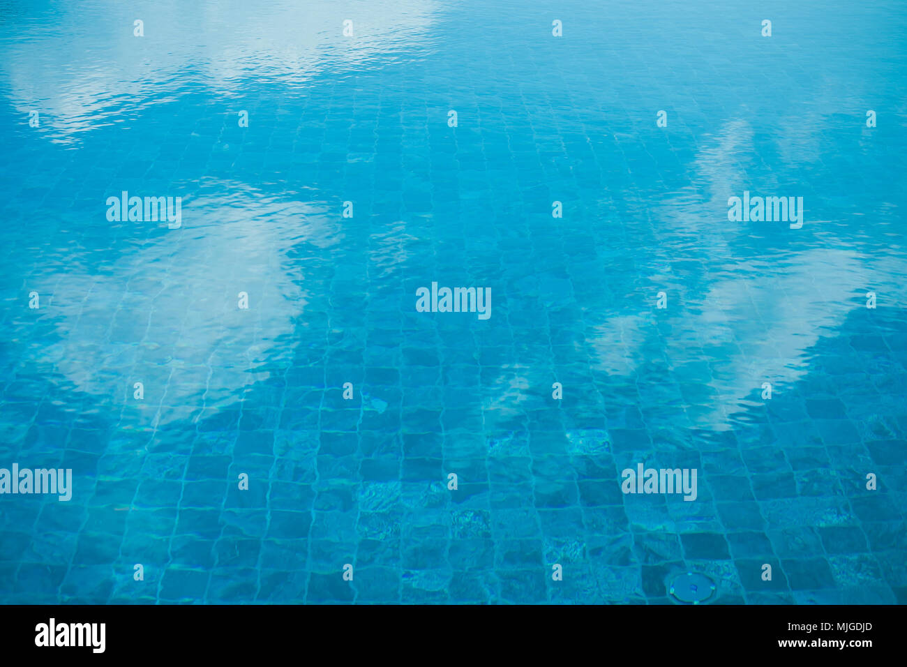Close up blue water in swimming pool reflection white clouds and blue ...