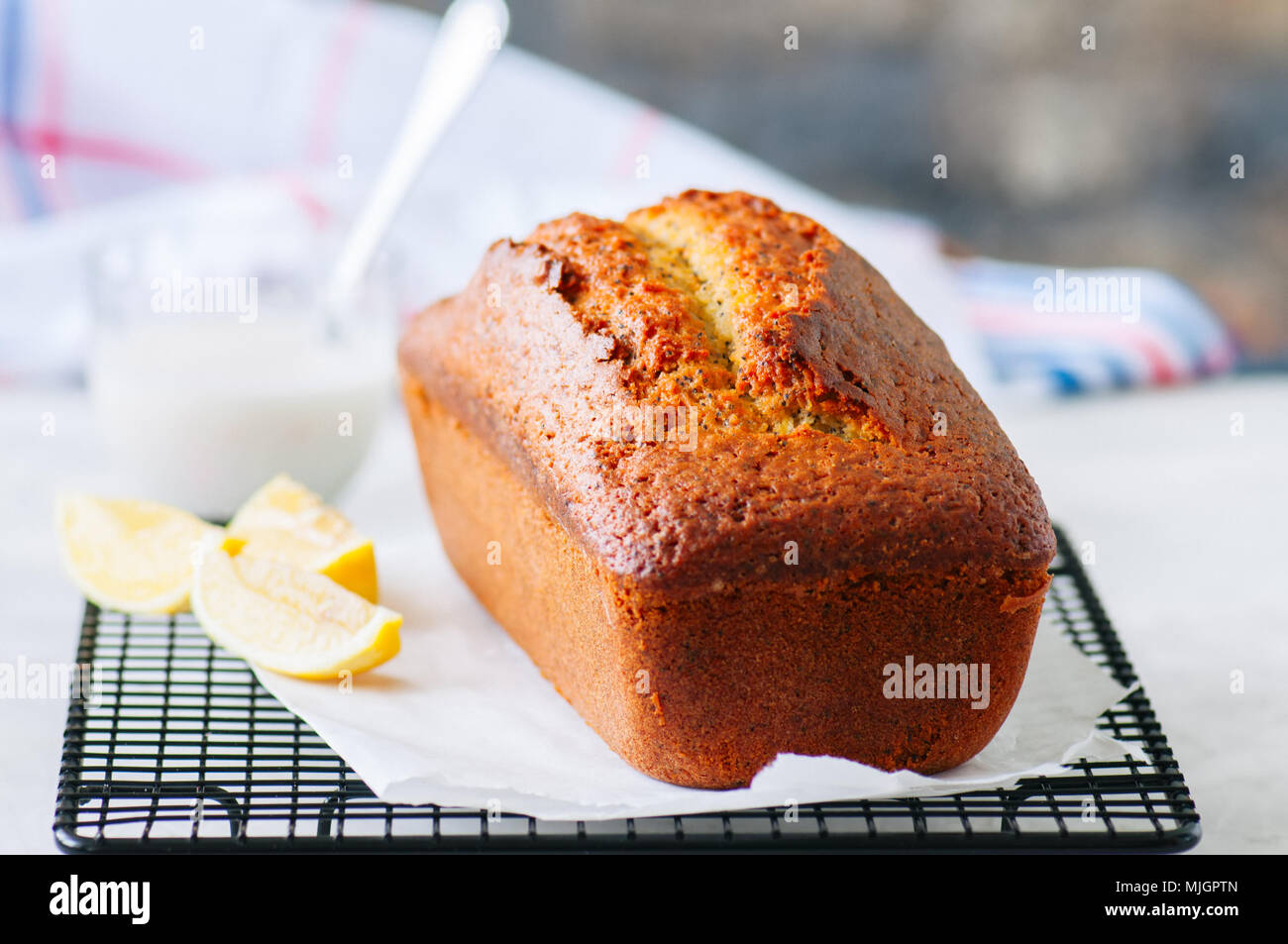 Homemade lemon poppy seed pound cake on a wire rack. White stone ...