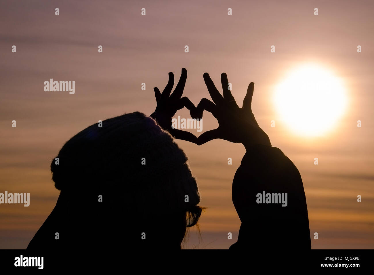 Love shape hand silhouette in the sky Stock Photo - Alamy